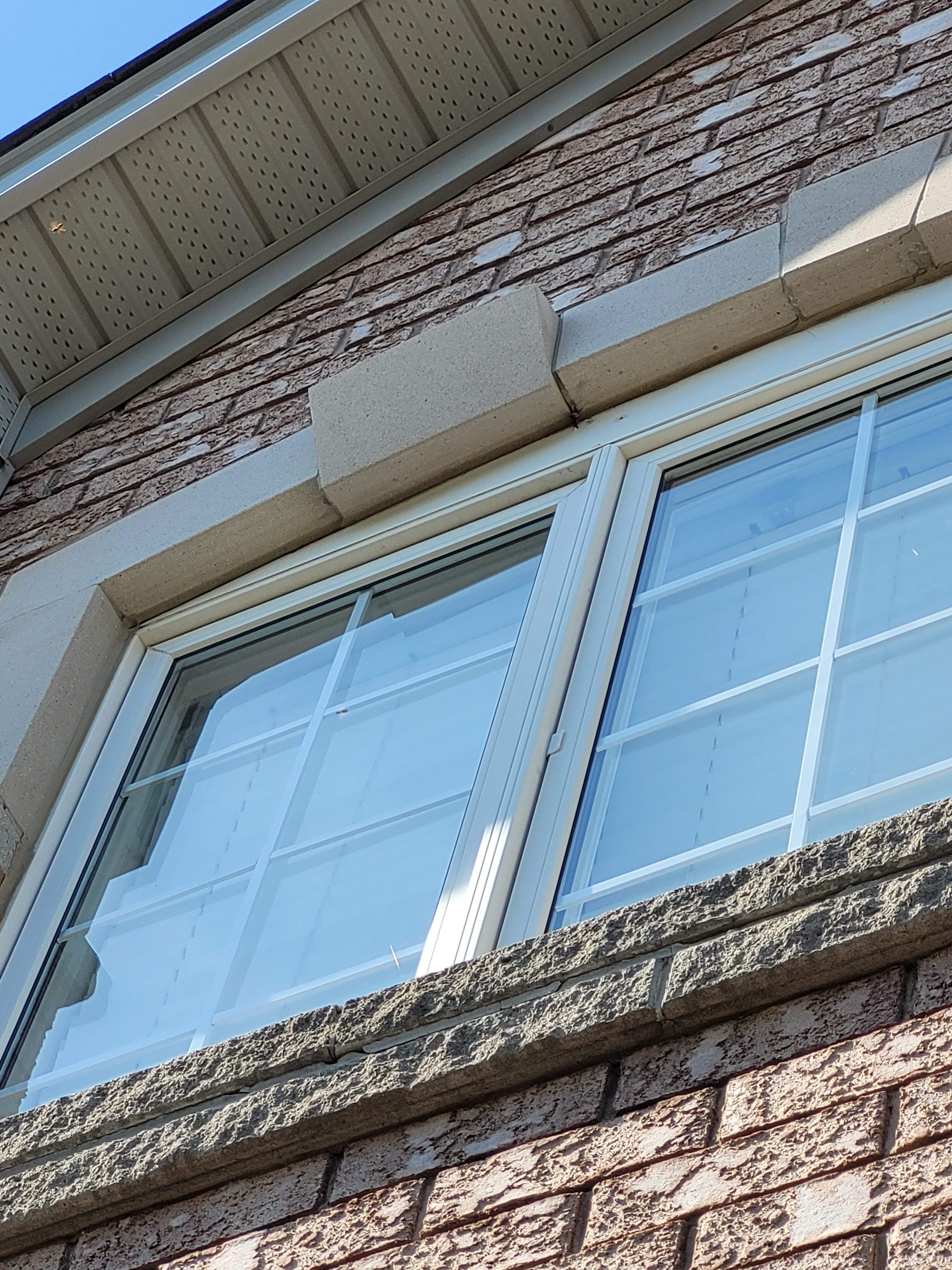 How to fix this ? Brick that's sticking out above window ...